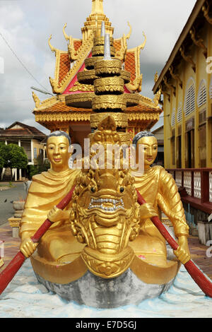 Golden statue of monks rowing on a churning seas of milk at Wat Dey Dos ...