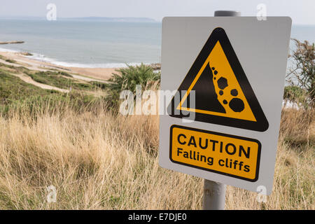 Caution -falling cliffs - warning sign on pathway above a sunlit sea ...