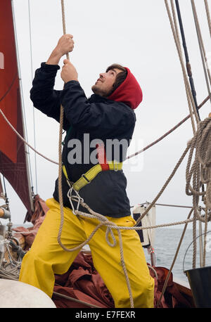 Young sailor on a ship's deck hoisting a sail Stock Photo - Alamy