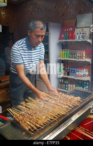 China Shanxi Pingyao street food market with ancient city walls in bkgd ...