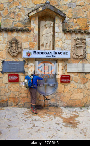 Pilgrim drinking wine at the Irache water and Rioja wine fountain on the Camino de Santiago ...
