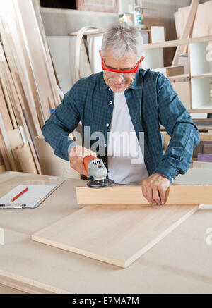 male carpenter Using Electric Sander for wood Stock Photo - Alamy