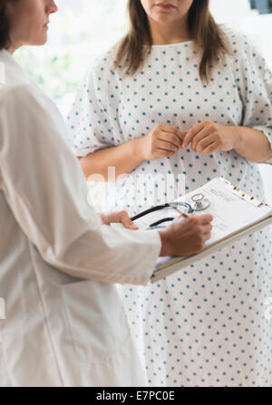 Two middle age doctors at medical clinic shocked covering mouth with ...