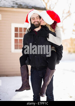 Young couple in Santa hat hugging on blue background, back view Stock ...
