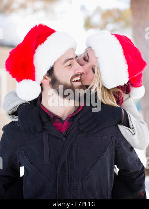Young couple in Santa hat hugging on blue background, back view Stock ...