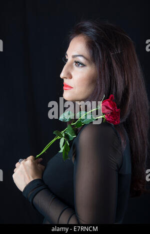 Middle age woman holding roses flowers on pot with open hand doing stop ...