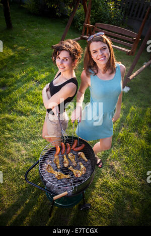 Two pretty girls making food on grill Stock Photo - Alamy
