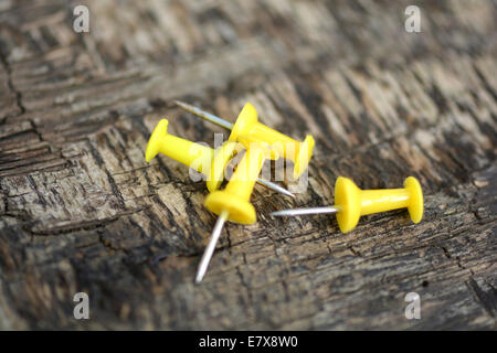 yellow push pins on old wooden background Stock Photo - Alamy