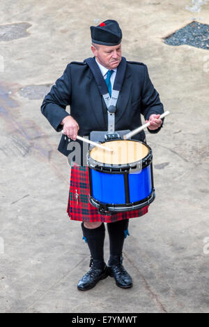 A young drummer in a Highland pipe band with her tenor drum in a ...