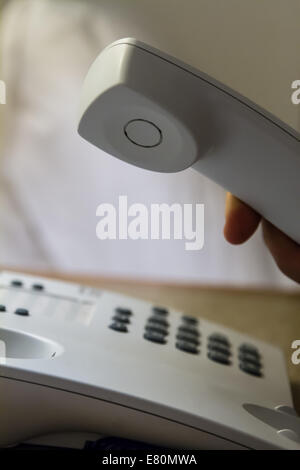 Hand holding white telephone tube isolated on white Stock Photo - Alamy