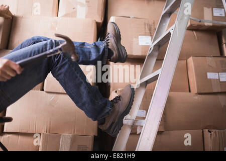 Worker falling off ladder in warehouse Stock Photo - Alamy