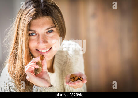 Woman eating almonds Stock Photo - Alamy