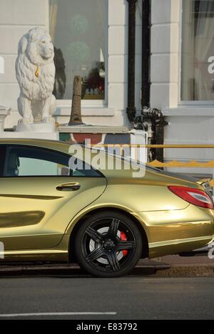 Gold painted Mercedes Benz sports sedan parked on Eastbourne seafront ...