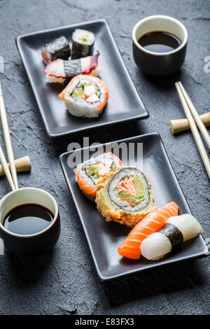 Sushi for two served in a black ceramic Stock Photo - Alamy