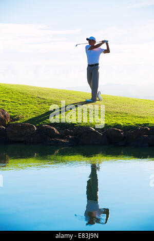 Silhouette of Man Playing Golf on Beautiful Course, Reflection in Water ...