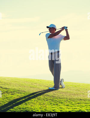 Golf player on golf course at sunrise Stock Photo - Alamy