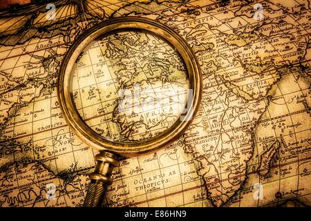 Vintage still life. Vintage magnifying glass lies on an ancient world ...