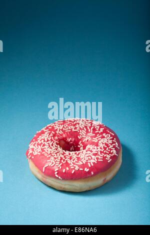 Single round donut on blue background Stock Photo - Alamy