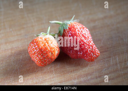 two strawberryes on the wooden plank Stock Photo - Alamy