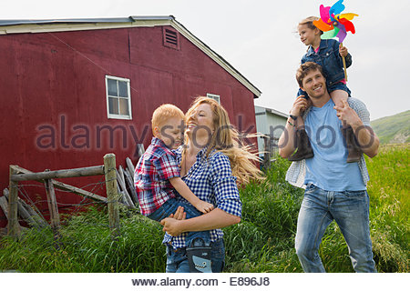 Happy parents carrying their children on shoulders Stock Photo - Alamy