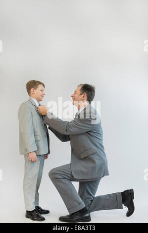 Father helping son binding his tie Stock Photo - Alamy