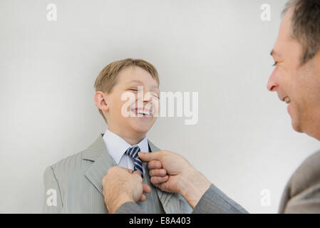 Father helping son binding his tie Stock Photo - Alamy