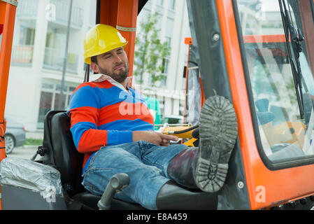 Construction worker sitting in excavator Stock Photo - Alamy