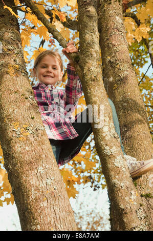 Children climbing a tree limb on the side of a lake Stock Photo - Alamy