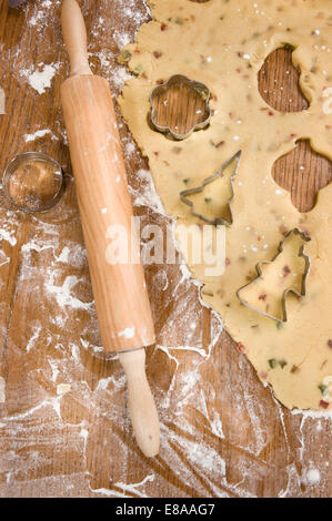 Dough with cookie cutters and rolling pin on kitchen table Stock Photo ...