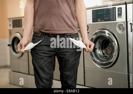 Young man pulling his empty pockets Stock Photo - Alamy