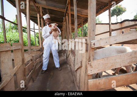 Rwandan butcher and meat producer poses next to his pig pens, Kigali ...