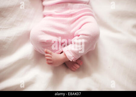 Baby girl is lying with her legs crossed Stock Photo - Alamy