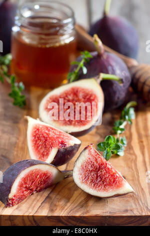fresh ripe figs fruit and olive branch on dark table. mediterranean ...
