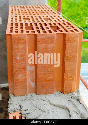 Block poroton placed on a bed grout on a bricklayer. Depth of field is ...
