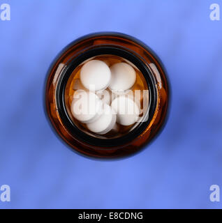 A high-angle shot of blue, brown, and white oval medicines on the ...
