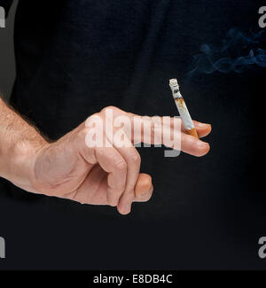 Hand is holding a cigarette on black background Stock Photo - Alamy