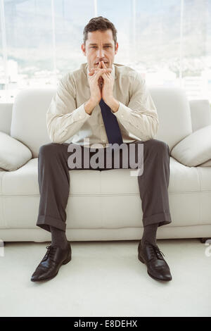 Young handsome businessman sitting on white cube Stock Photo - Alamy