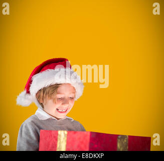 Composite image of festive boy opening gift Stock Photo - Alamy