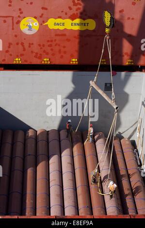 Workers Offloading Pipe from Cargo Ship Stock Photo - Alamy