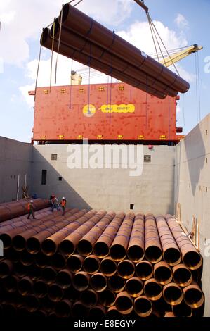 Workers Offloading Pipe from Cargo Ship Stock Photo - Alamy