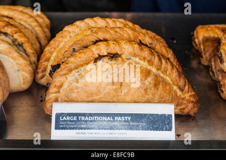 An old-fashioned shop front displaying many enamel advertising signs ...
