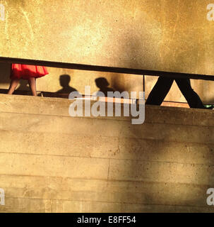 People walking along a wall Stock Photo - Alamy