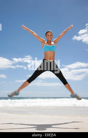 Woman doing star jump outdoors, in public park Stock Photo - Alamy
