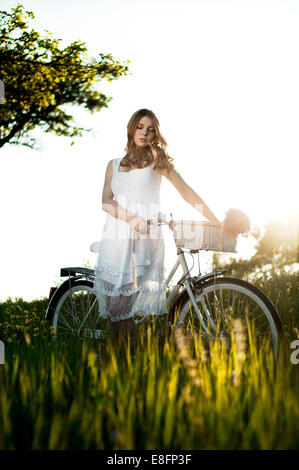 Young blonde fashioned woman standing on a suspension bridge in Austria ...