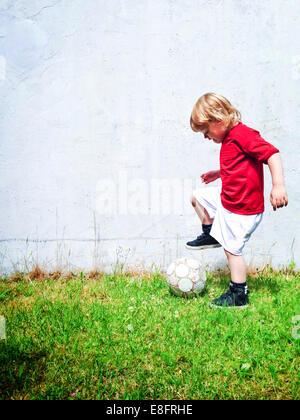 Boy child playing football on football field. Kid playing soccer. Child ...
