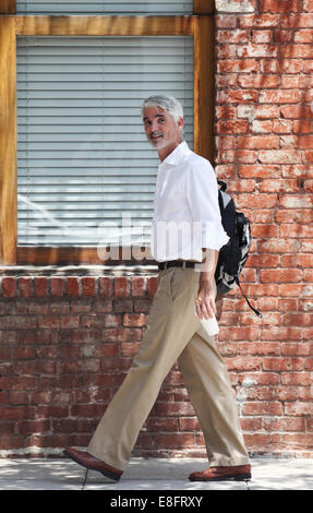 Businessman Walking Past Building Stock Photo - Alamy