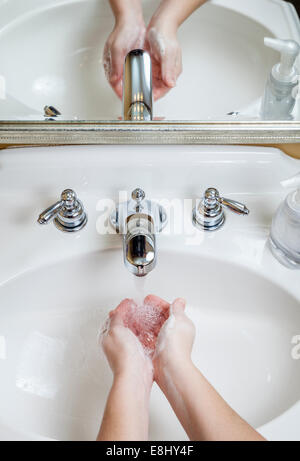 Woman washing hands with soap at sink in bathroom, closeup Stock Photo ...
