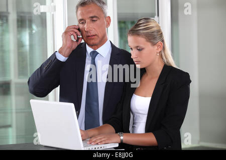 Assistant stood with boss Stock Photo - Alamy