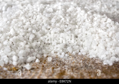 Large white sea salt crystals in a natural wooden bowl and spoon full ...