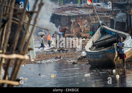 Woman and boys in polluted river, Kroo Bay, Freetown, Sierra Leone ...